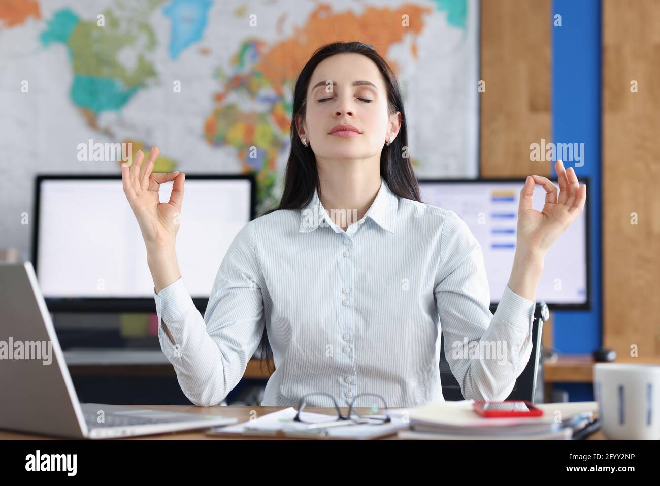 Calm business woman doing yoga exercises in workplace Stock Photo - Alamy