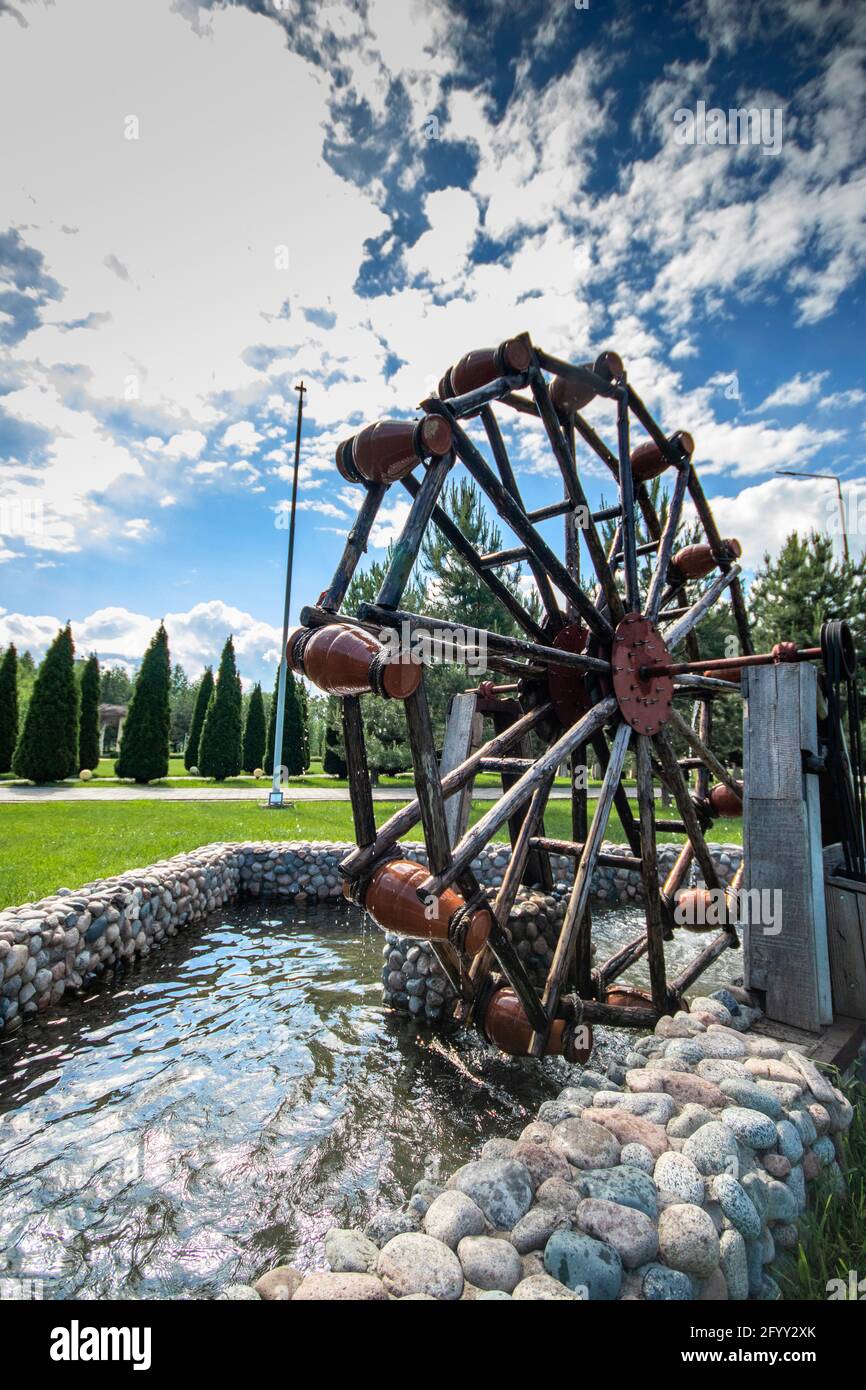 Decorative garden pond with with jugs on a movable wheel on an electric ...