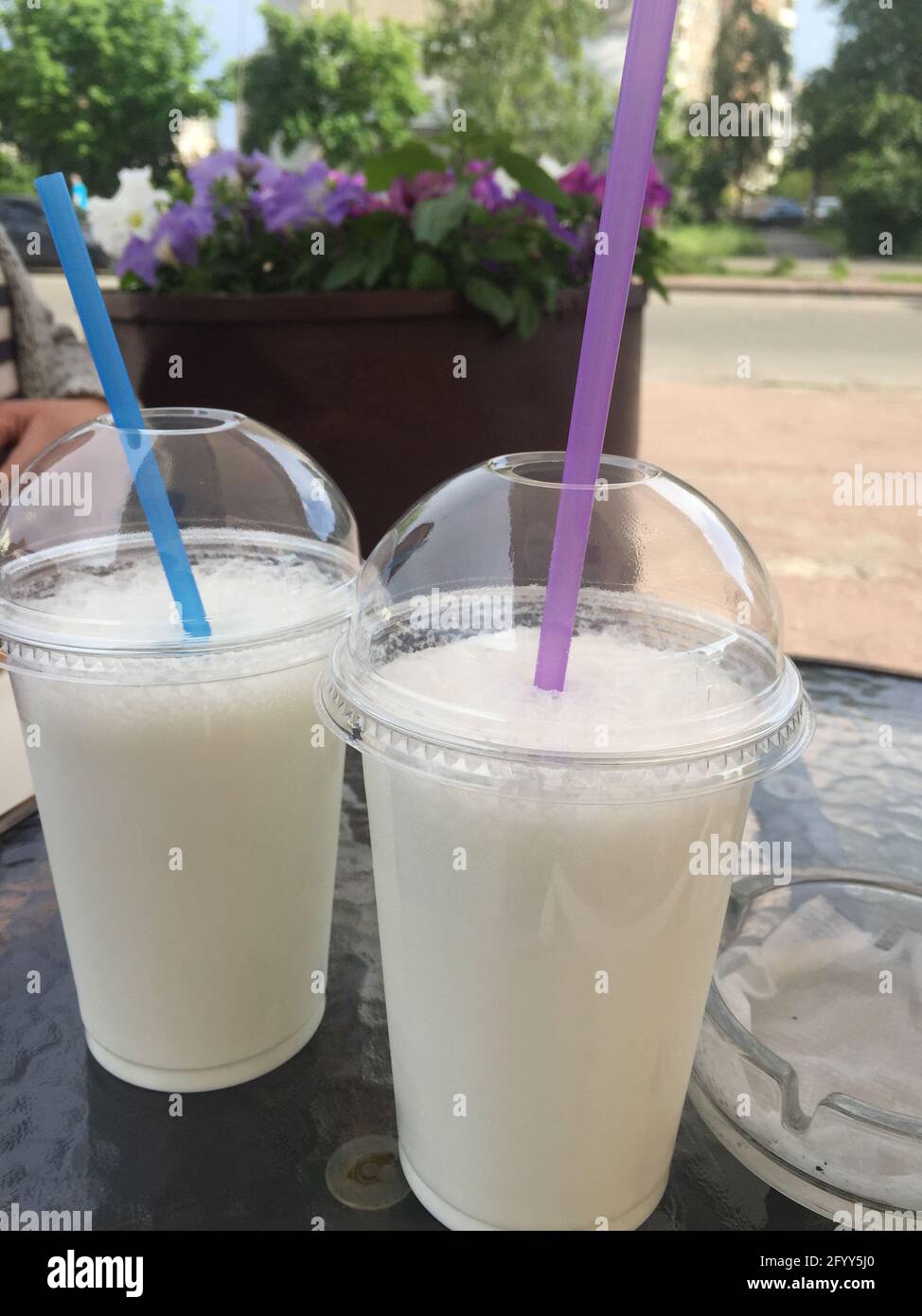 Cold milkshake with straw on summer terrace in cafe Stock Photo - Alamy