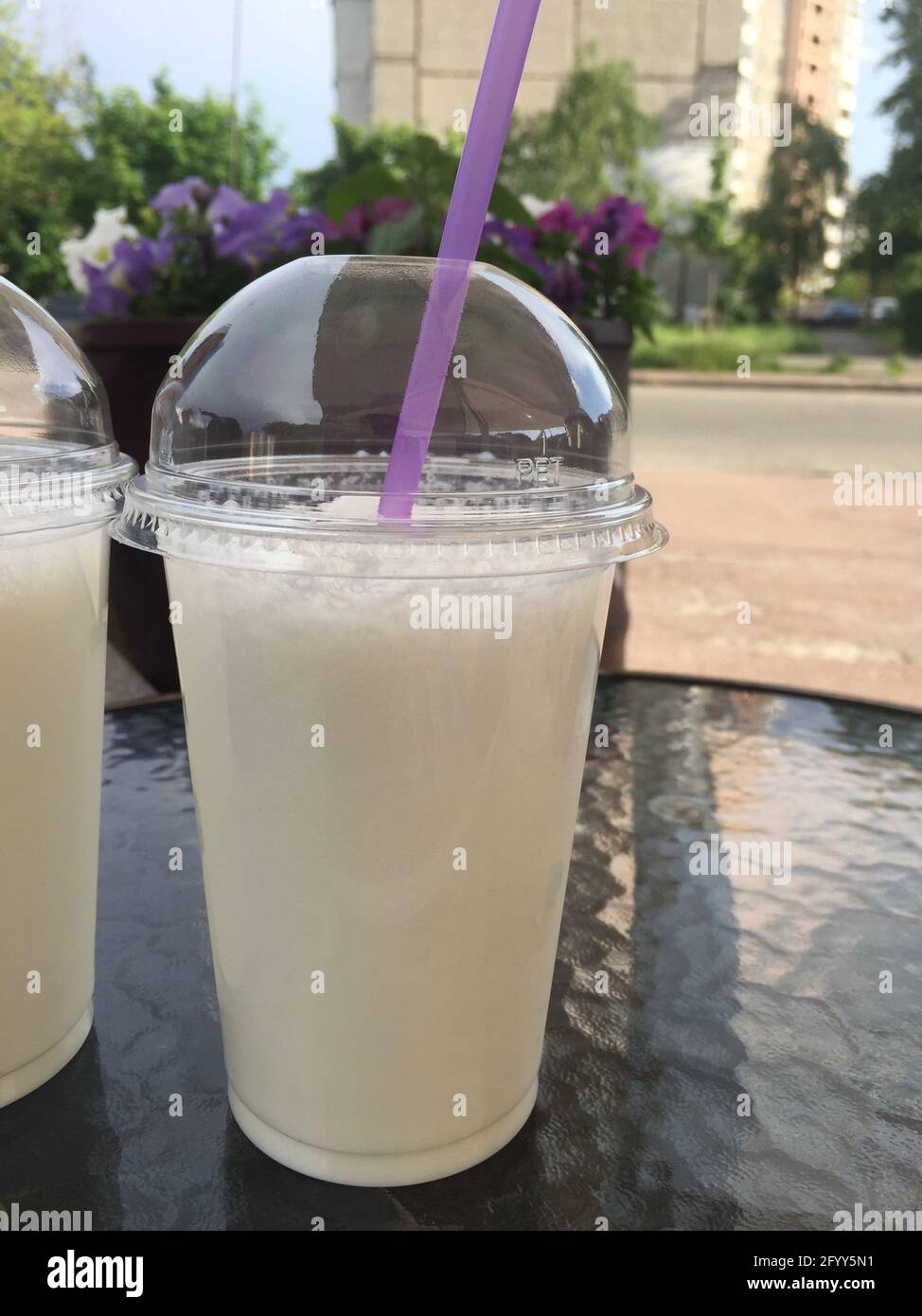 Cold milkshake with straw on summer terrace in cafe Stock Photo - Alamy