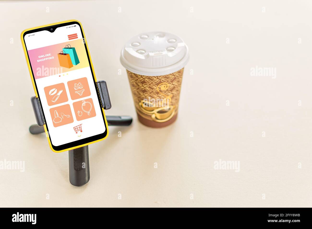A takeaway cup of coffee and smart phone with a shopping app - online ...