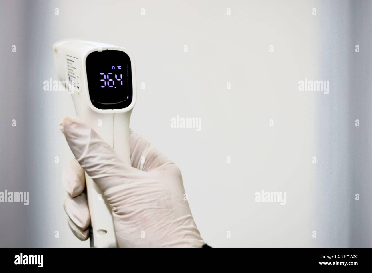 Non contact infrared forehead digital thermometer gun held by a medical ...