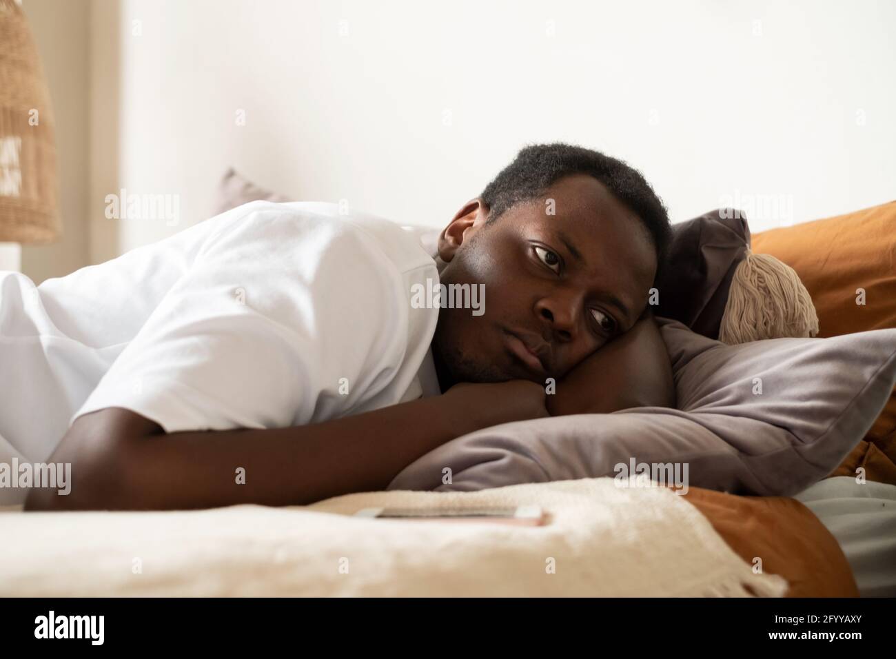 Lonely african man in bed with mobile smartphone waiting for call Stock ...