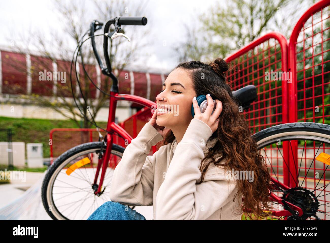 Full body of glad young female with eyes closed enjoying music in ...