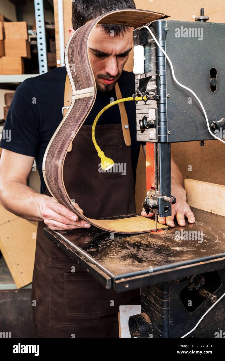 Crop focused craftsman building wooden musical instrument on ...