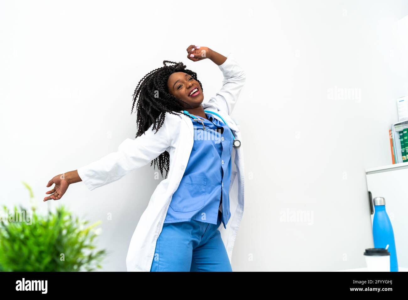 African American Woman in medical uniform dancing in doctor office ...