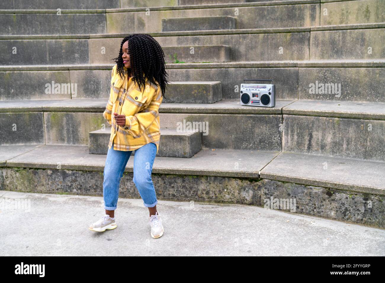 Side view of African American female dancing while listening to music ...