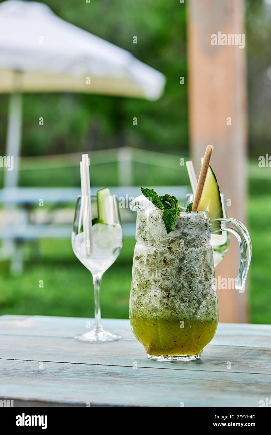 From above glass jug of cold rum cocktail with melon and mint placed on ...