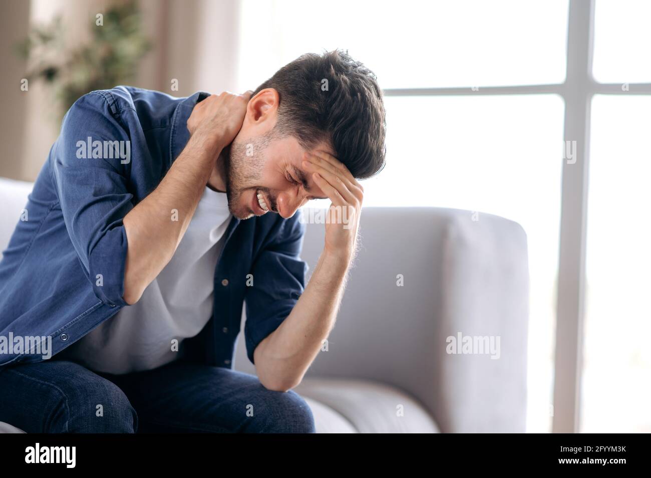Sick sad upset caucasian man in casual clothes sitting on sofa in ...