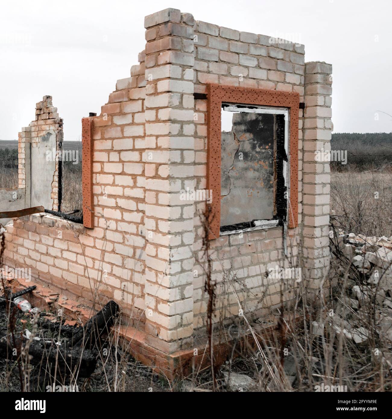 Destroyed and burnt brick structure with a window at the edge of the ...