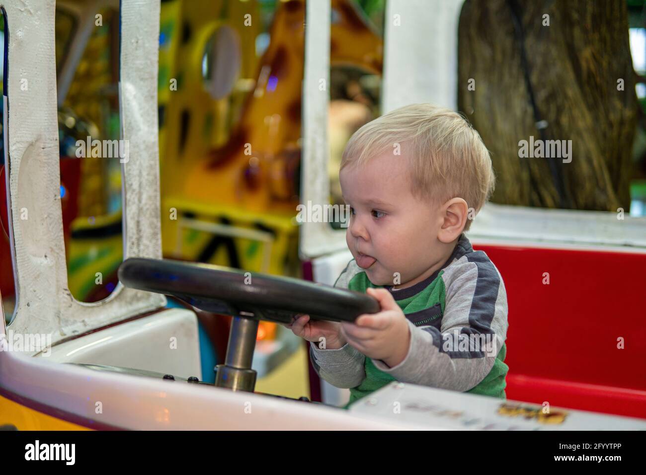 Funny little smiling kid boy driving toy car Stock Photo - Alamy