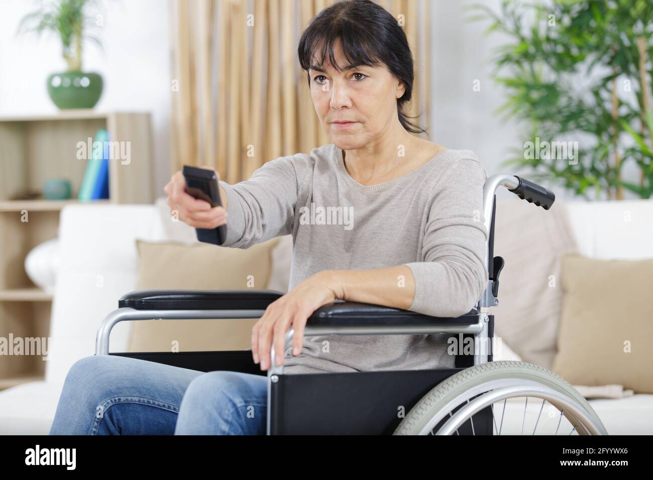 disabled mature woman in wheelchair watching tv Stock Photo - Alamy