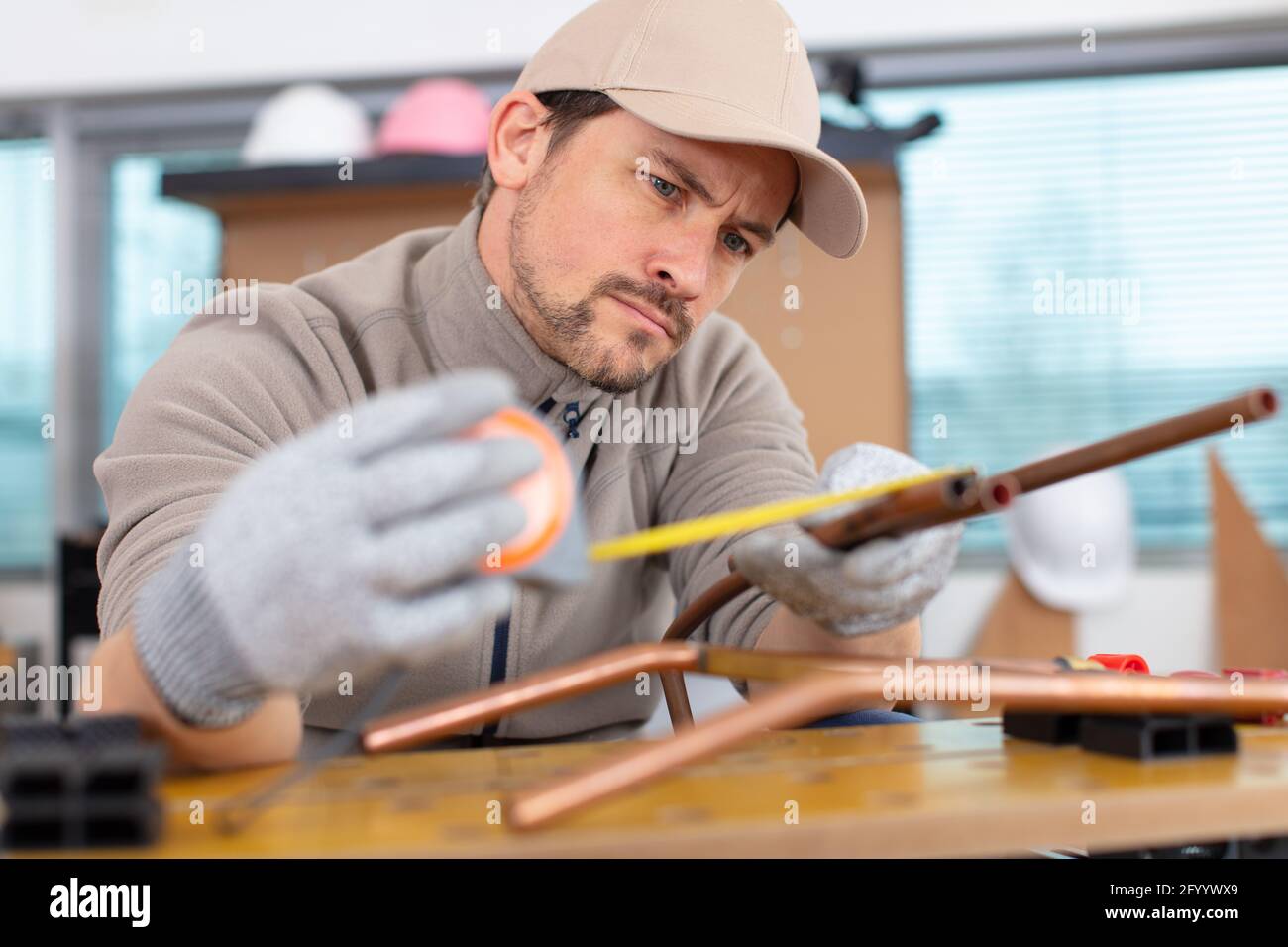 young plumber measuring copper pipe Stock Photo - Alamy