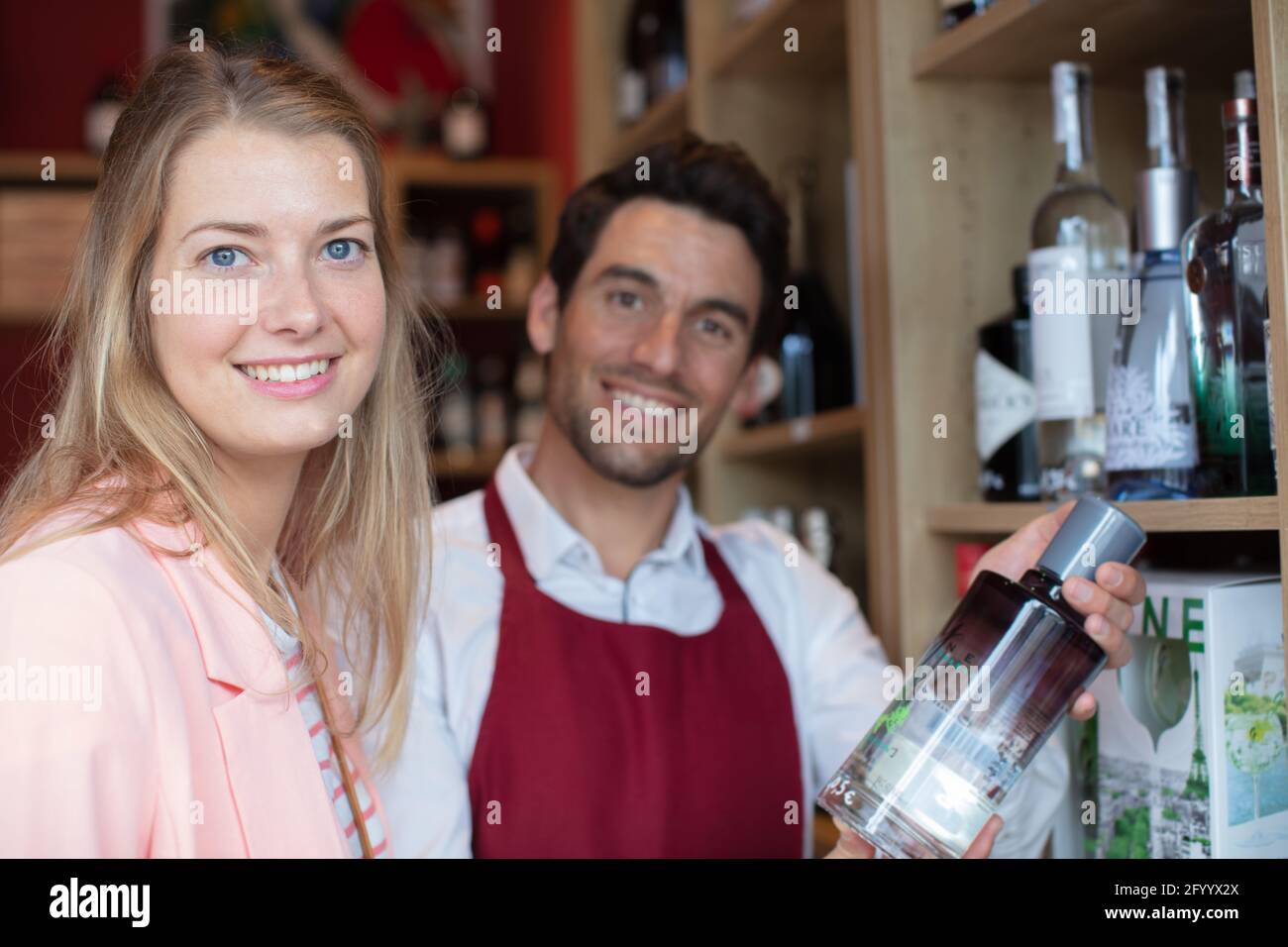 portrait of positive male seller in uniform with customer Stock Photo ...