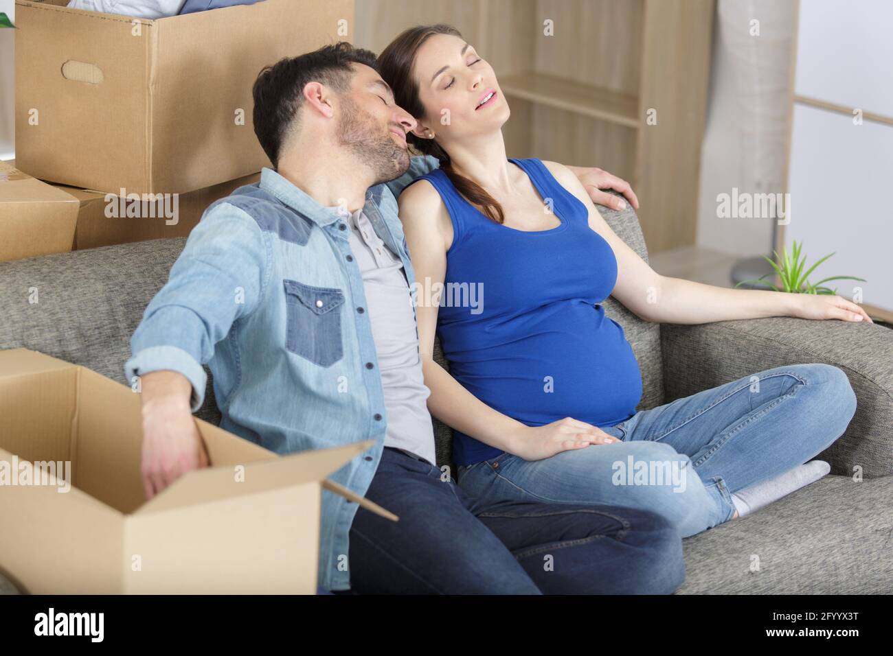 tired pregnant couple napping on the sofa Stock Photo - Alamy