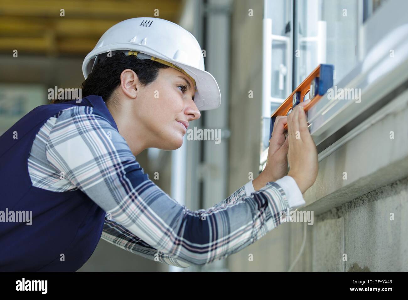 female worker using a spirit level on a window sil Stock Photo - Alamy