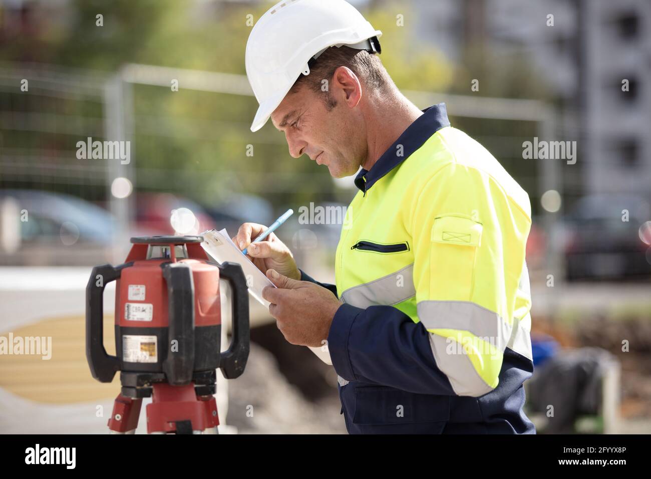 mature geometer working on construction site Stock Photo - Alamy