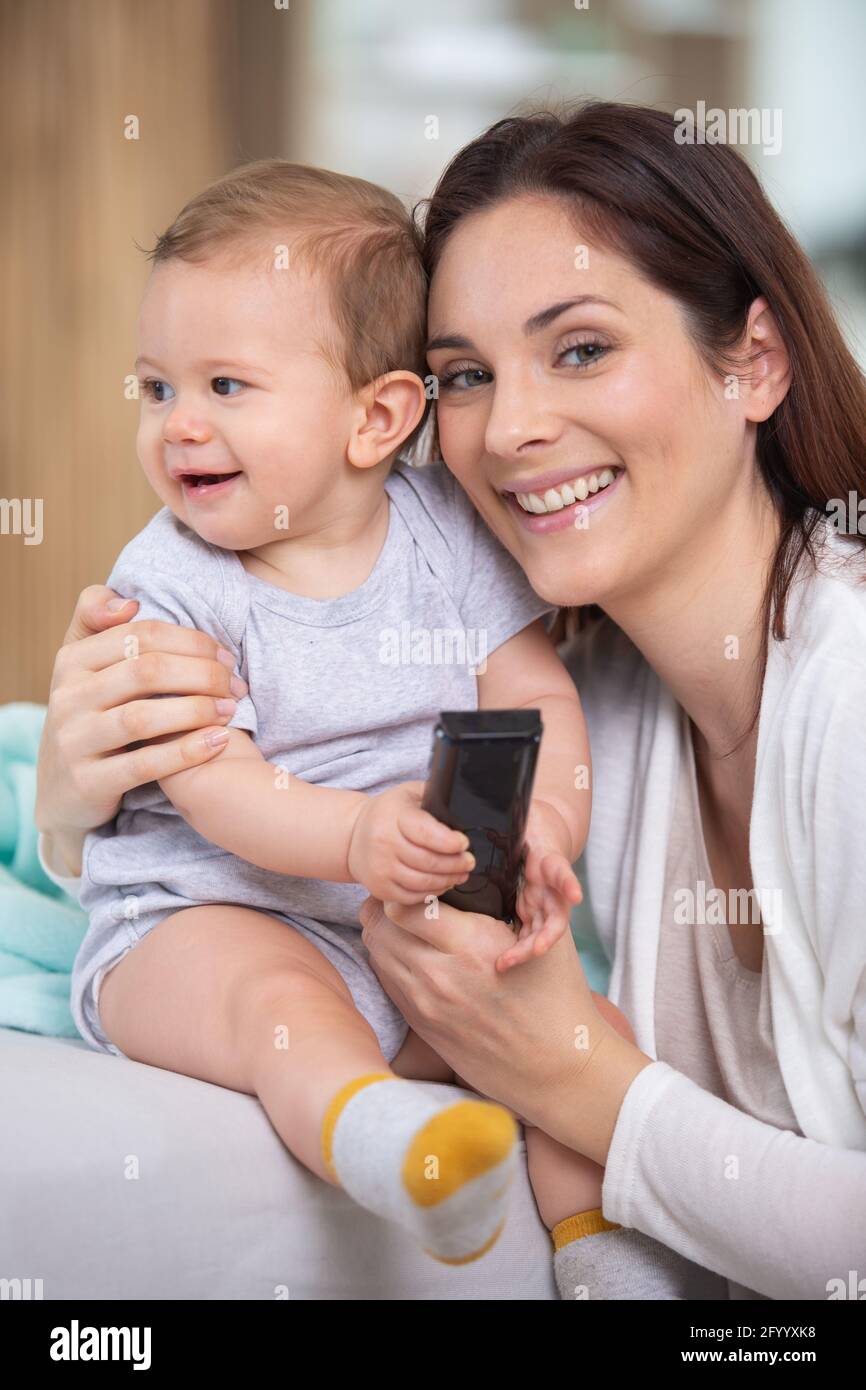 happy smiling baby holding a remote control tv Stock Photo - Alamy