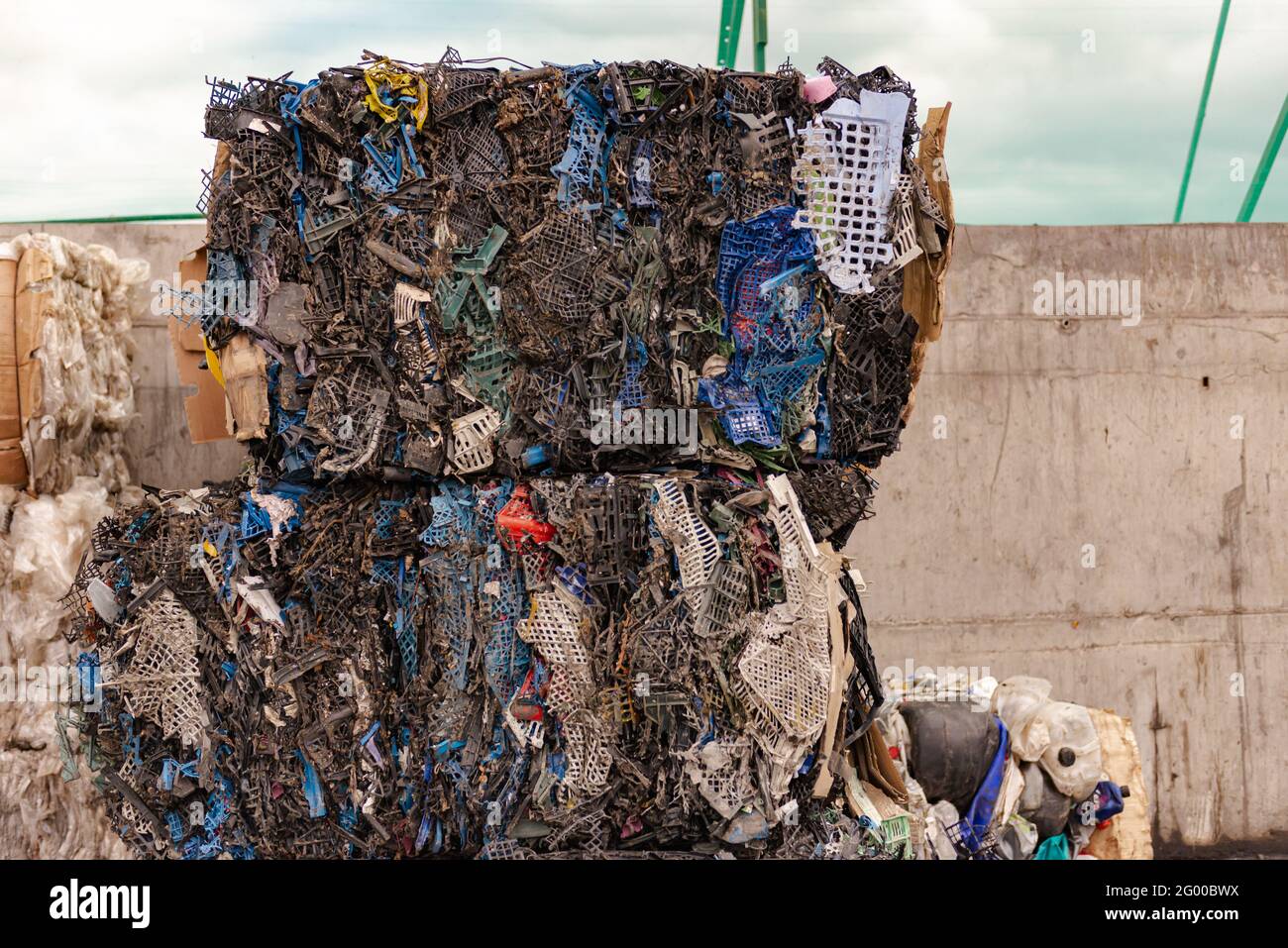 Plastic boxes of vegetables and fruits are pressed in a garbage factory ...