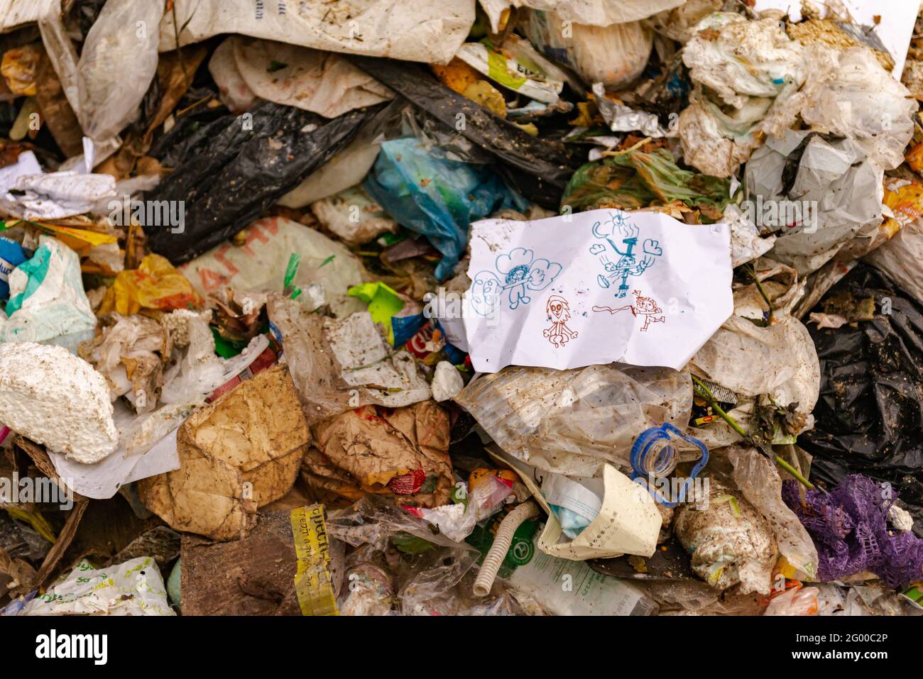 Children's drawing in a garbage heap. On top of a large pile of garbage ...