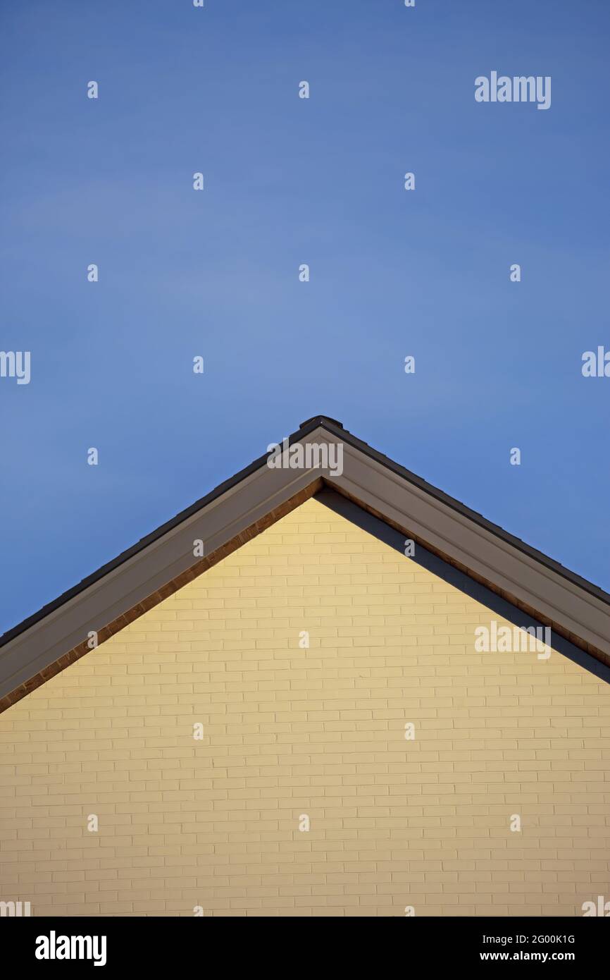 Vertical shot of the building roof in a triangle form with light yellow ...