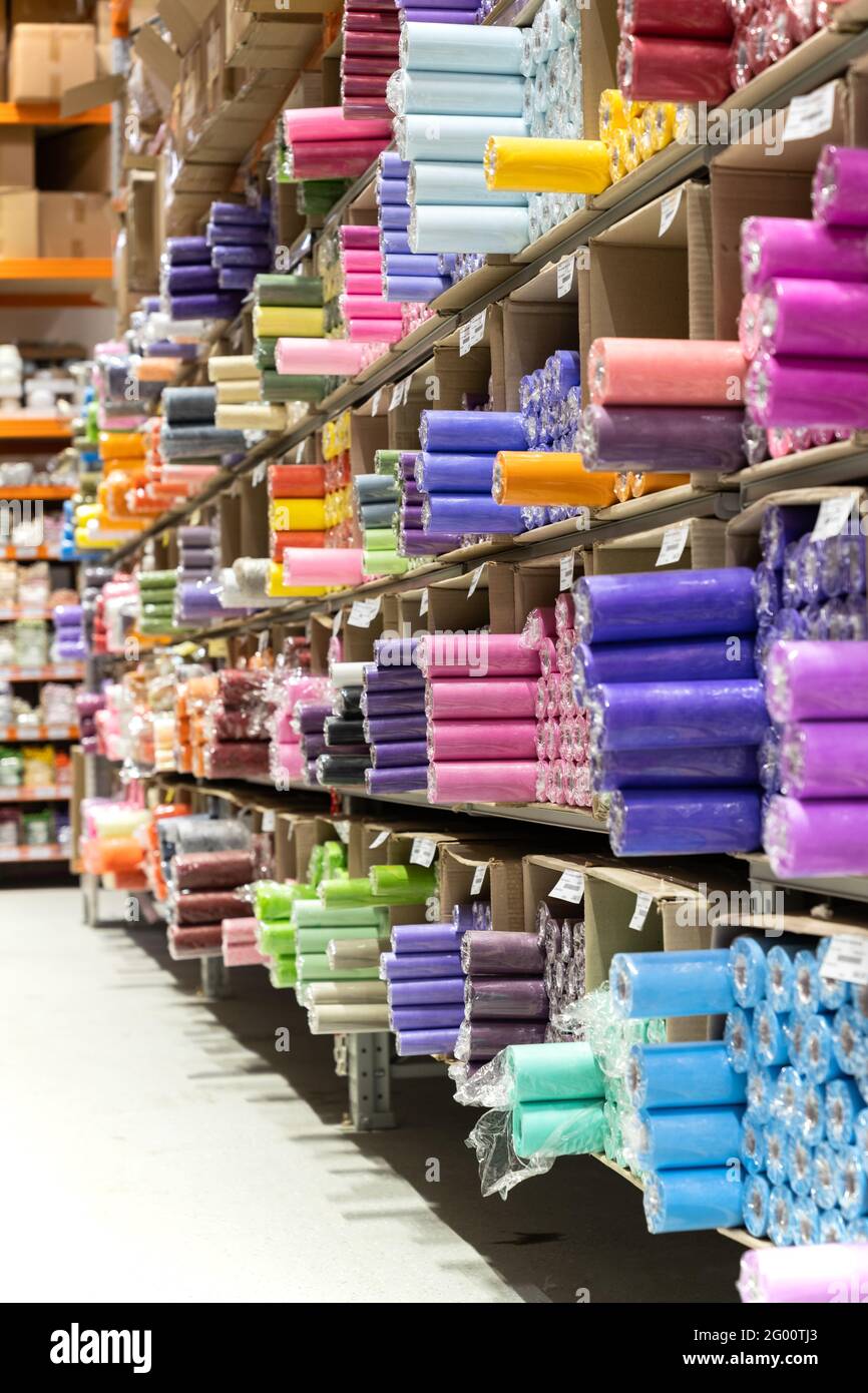 Fabric store with rolls of textile on shelves. Assortment of colorful ...