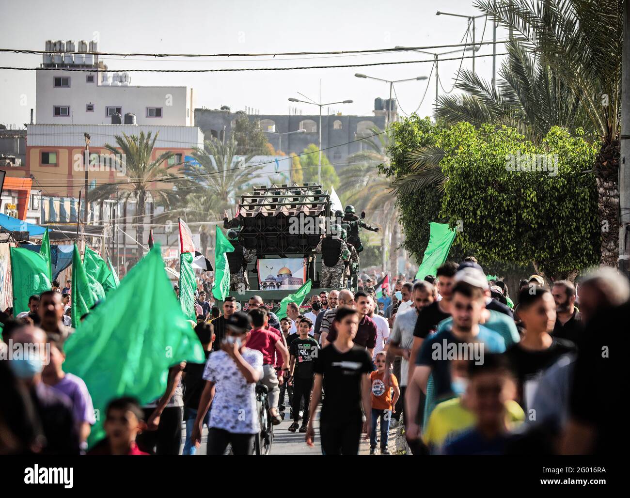 Palestinians gather as Hamas militants with weapons take part during ...