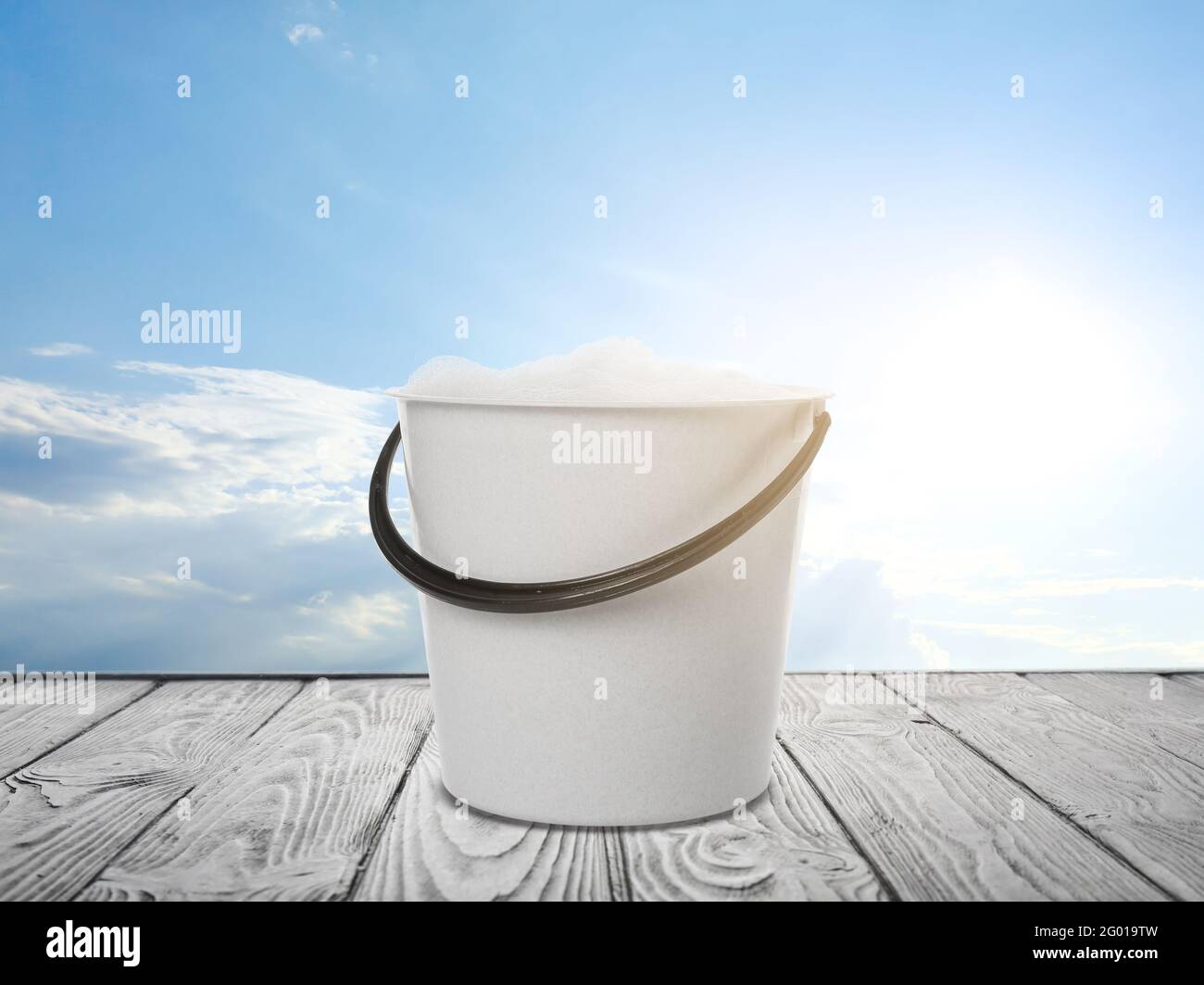 Plastic bucket with foam on wooden table outdoors Stock Photo - Alamy