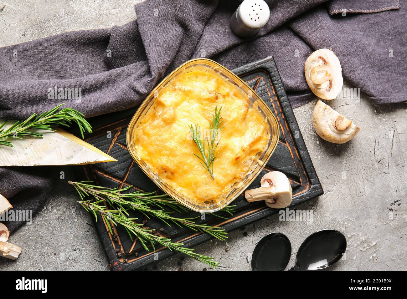 Baking dish with tasty julienne and ingredients on grey background ...