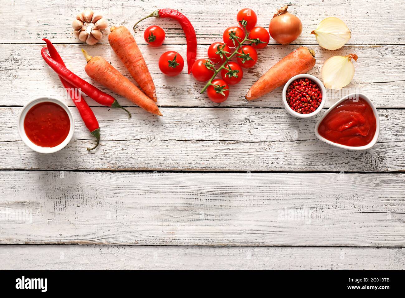 Composition with tasty chili sauce and ingredients on light wooden ...