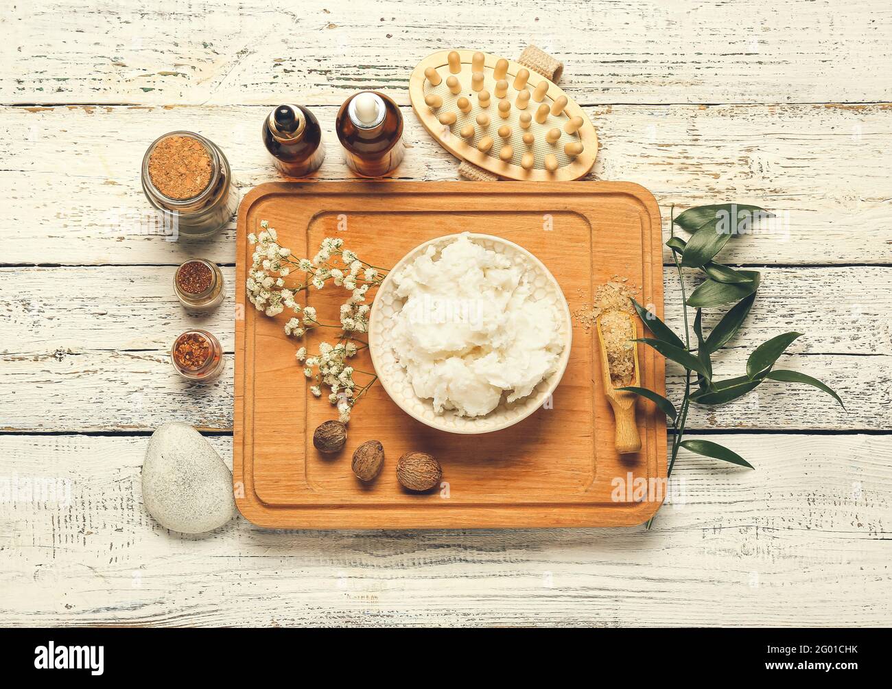 Composition with shea butter, nuts and bath supplies on light wooden ...