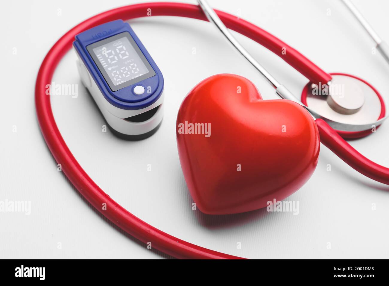 Red heart with pulse oximeter and stethoscope on white background Stock ...