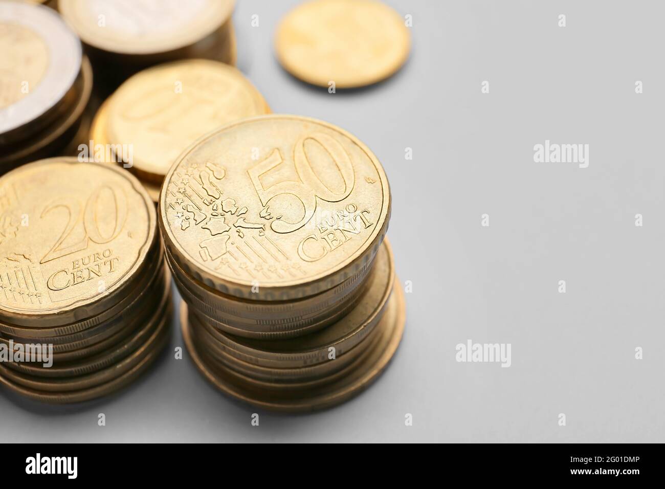 Stacked coins on grey background Stock Photo - Alamy