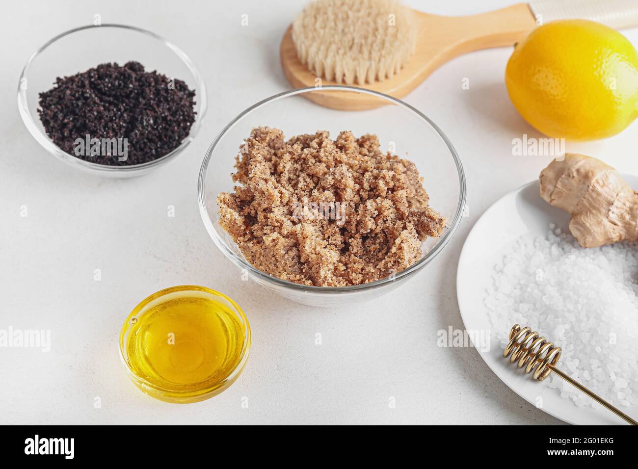 Bowl with natural scrub, ingredients and massage brush on white ...
