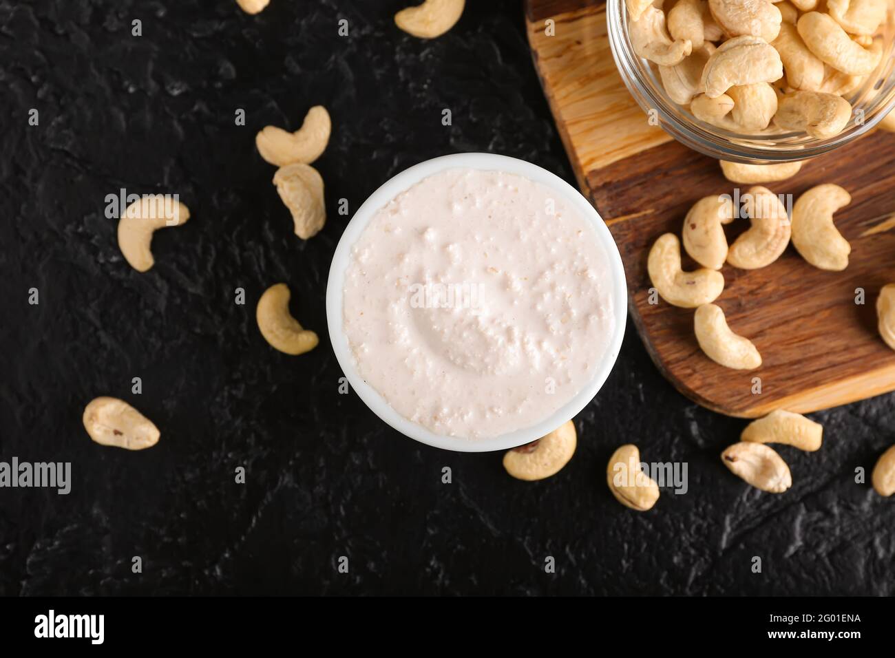 Bowl with cashew sour cream and nuts on dark background Stock Photo - Alamy