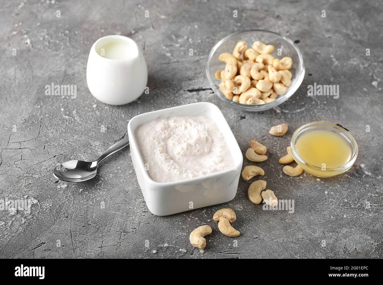 Composition with cashew sour cream, nuts and lemon juice on grey ...
