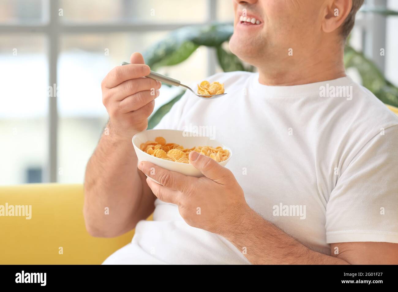 Senior man eating cornflakes at home Stock Photo - Alamy
