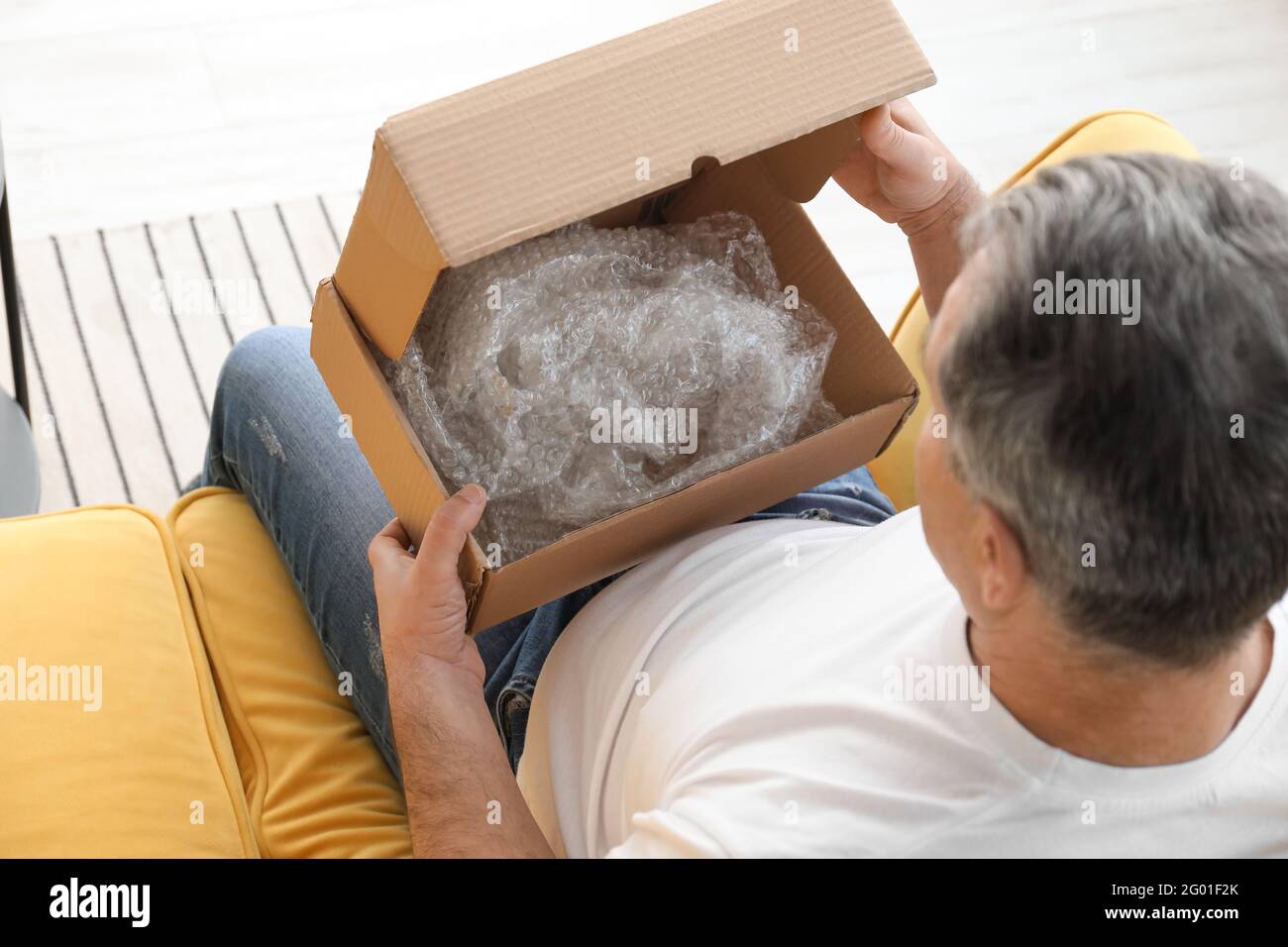 Senior man unpacking box at home Stock Photo - Alamy