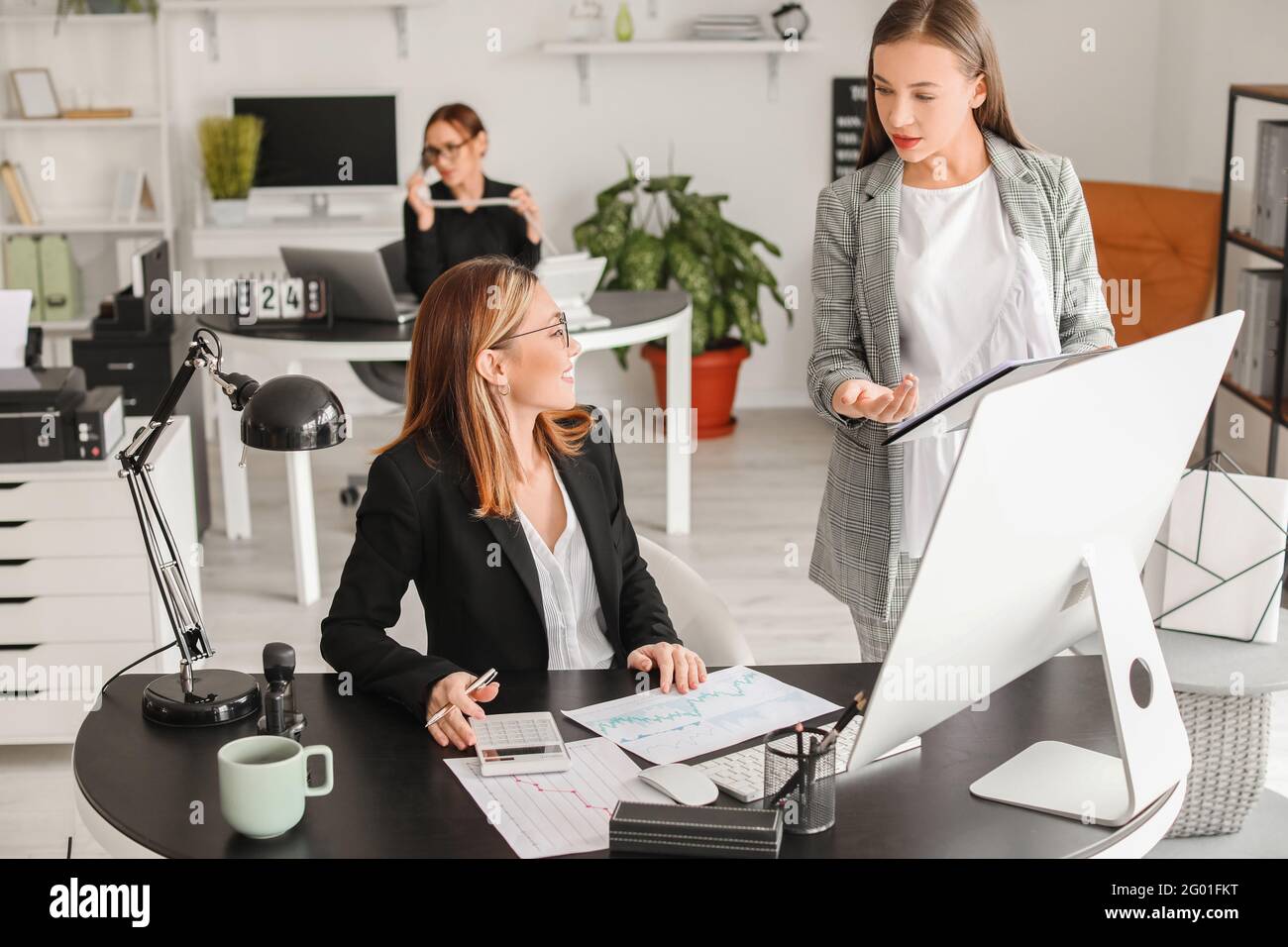 Female accountants working in office Stock Photo - Alamy