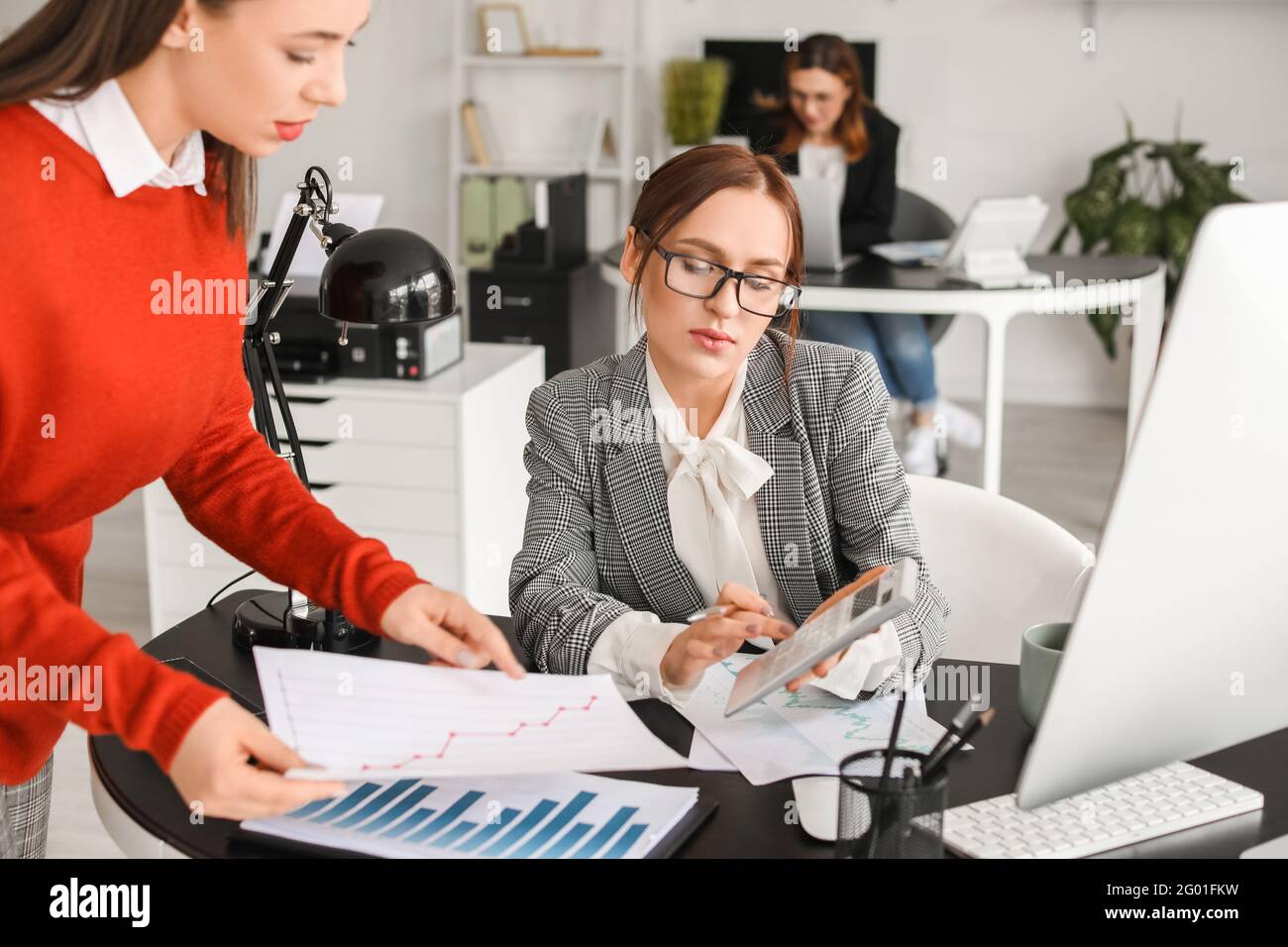 Female accountants working in office Stock Photo - Alamy