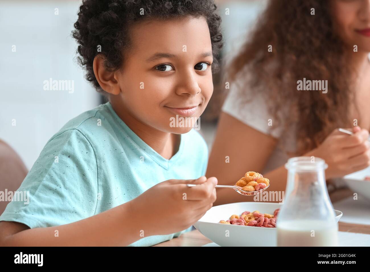 Little boy with mother eating cornflakes at home, closeup Stock Photo ...