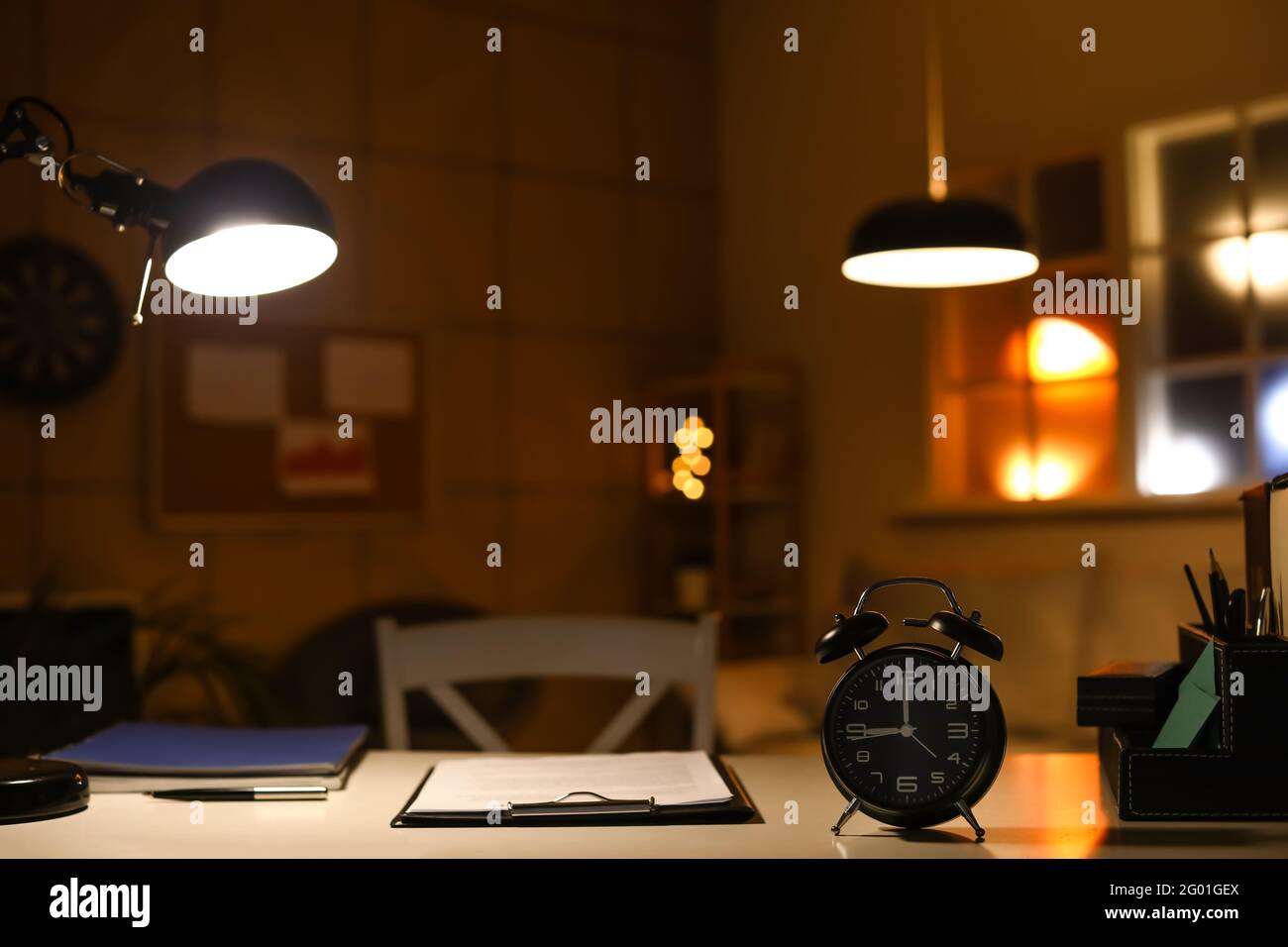 Stylish alarm clock on table in room Stock Photo - Alamy