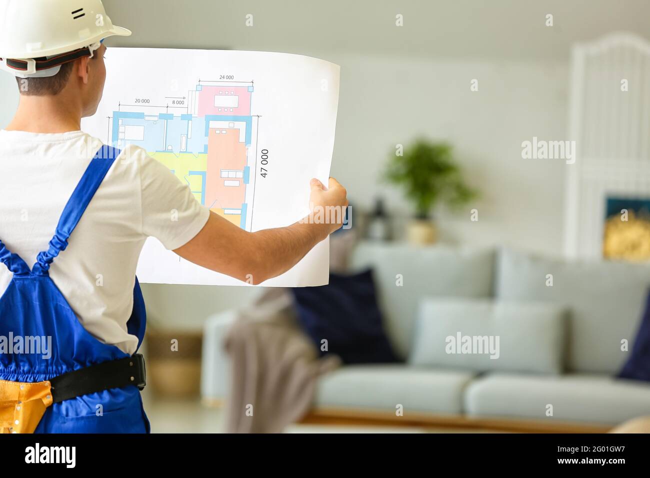 Young electrician with house plan in room Stock Photo - Alamy