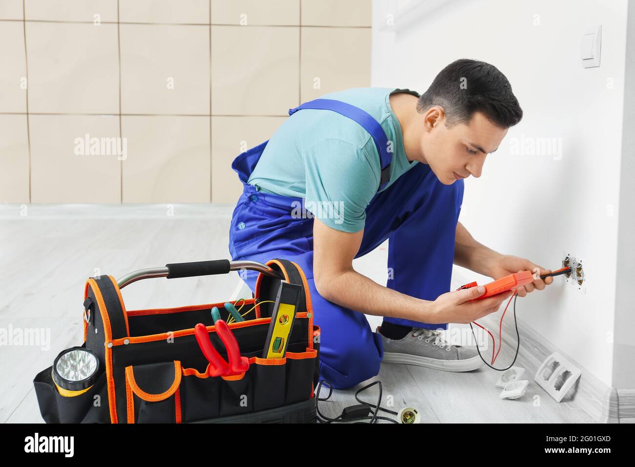 Young electrician measuring voltage of socket in room Stock Photo - Alamy
