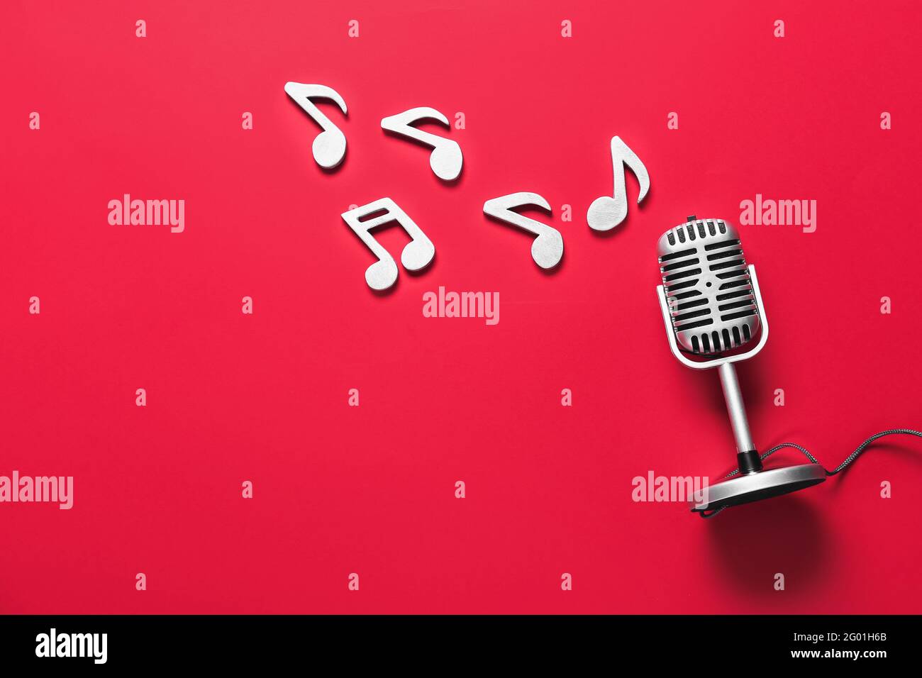 Retro microphone with music notes on color background Stock Photo - Alamy