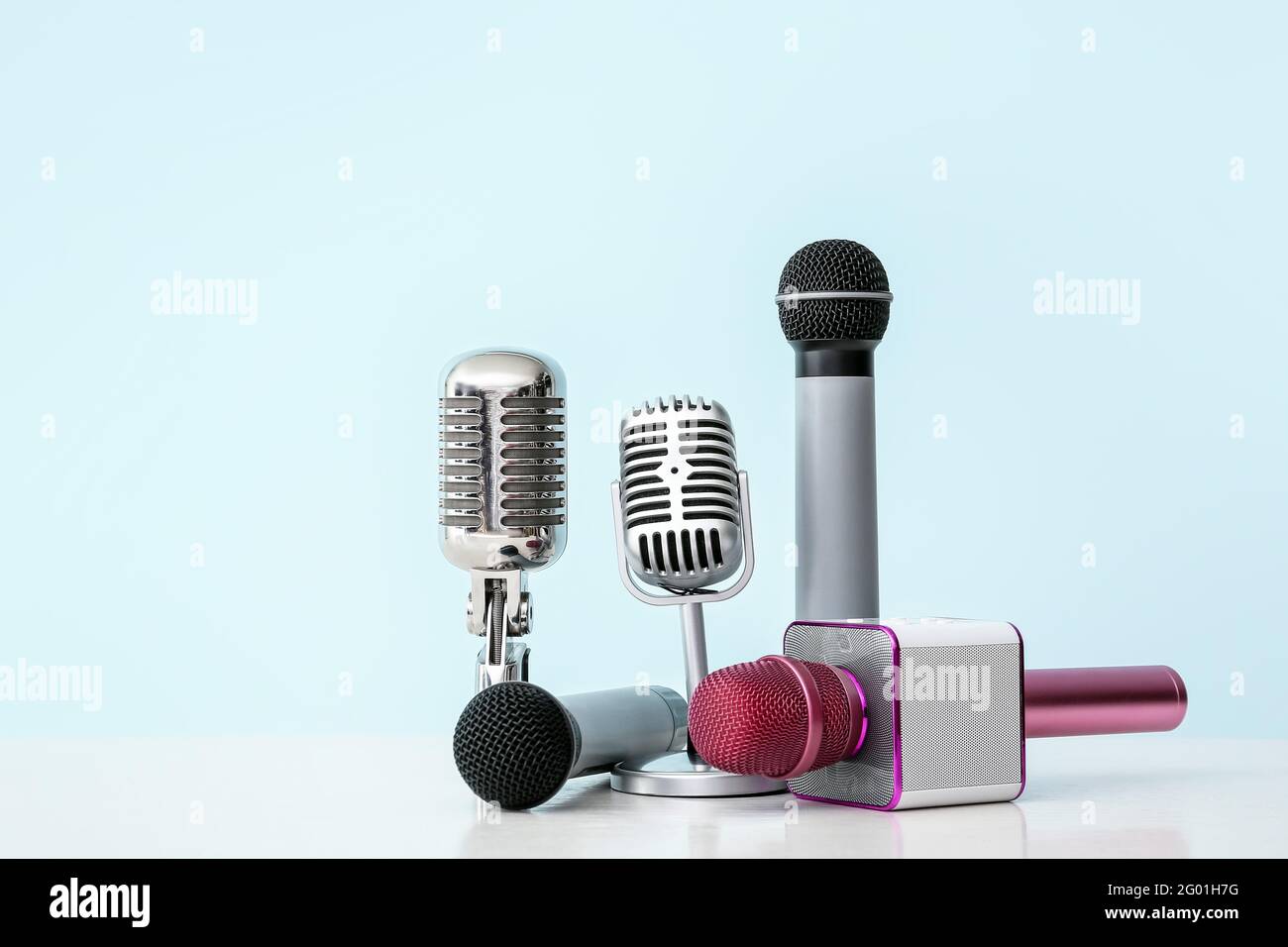 Different microphones on color background Stock Photo - Alamy