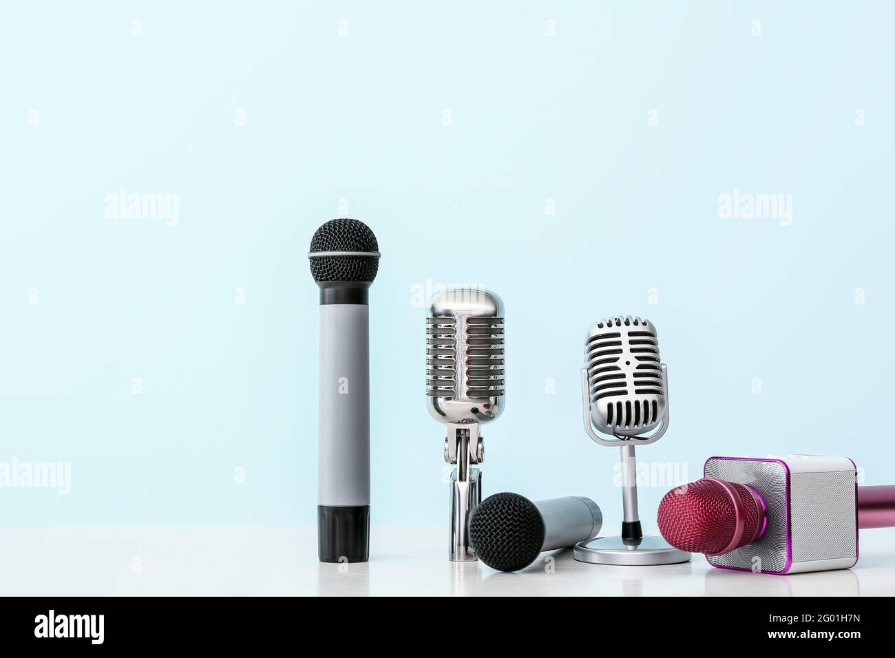 Different microphones on color background Stock Photo - Alamy