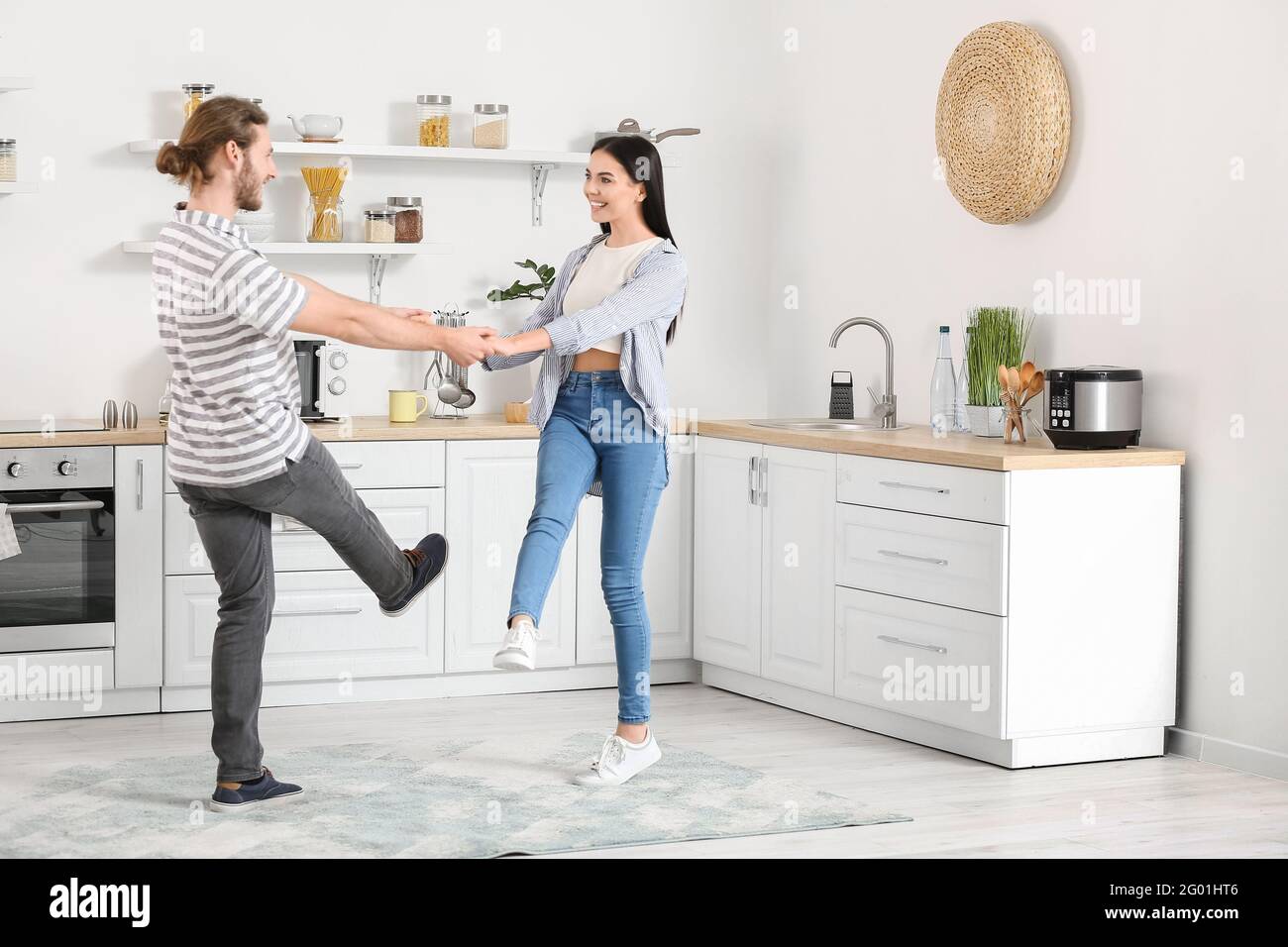Happy young couple dancing in kitchen Stock Photo - Alamy