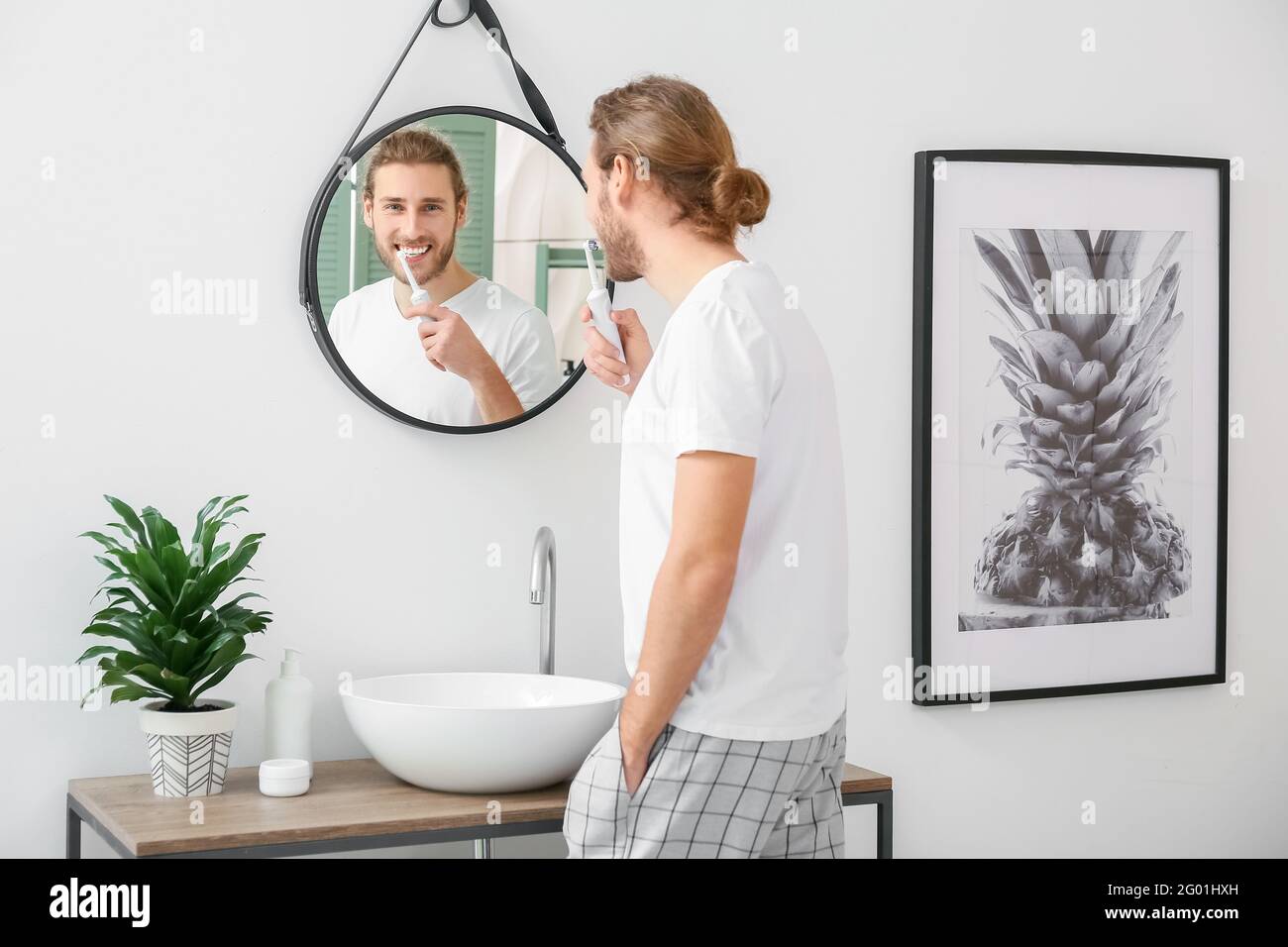 Young man brushing teeth in bathroom Stock Photo - Alamy