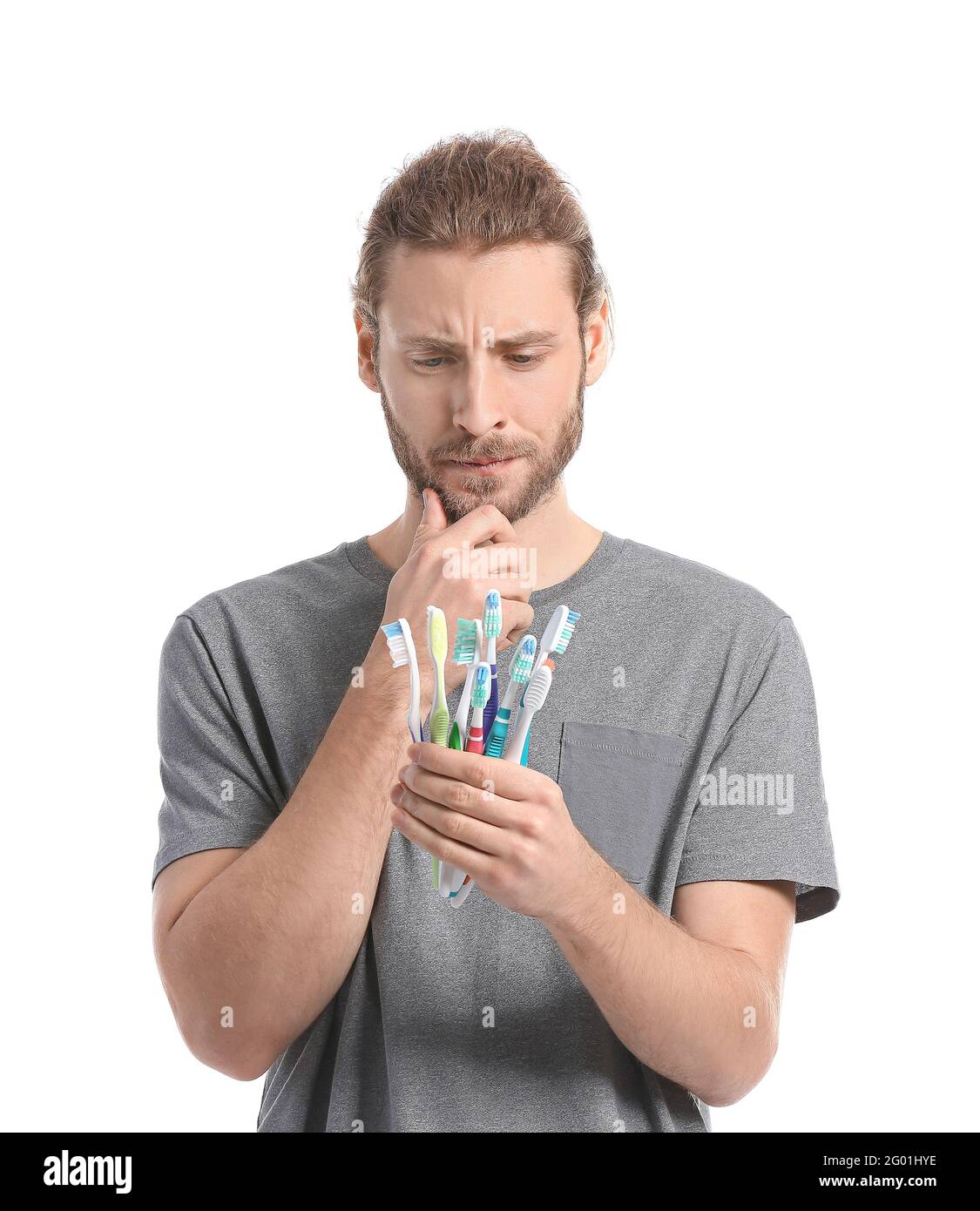 Thinking handsome man with tooth brushes on white background Stock ...